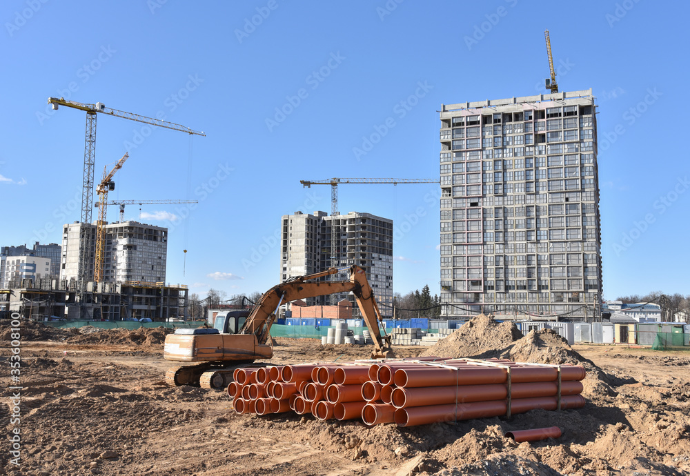 Tower cranes constructing residential buildings. Excavator on ...
