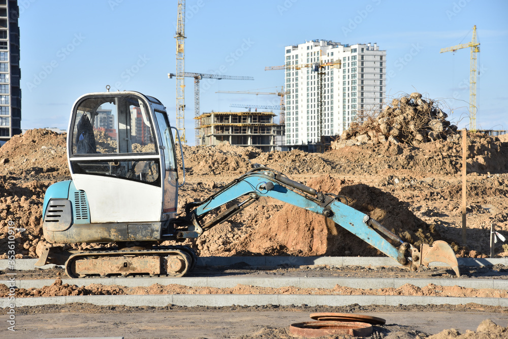 Mini excavator digg trench to lay cables concrete curbs and paving ...