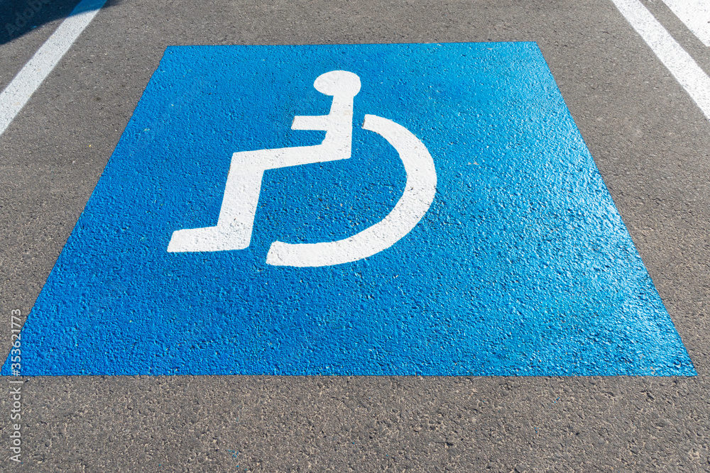 Parking lot with painted handicapped symbol of wheelchair on asphalt ...