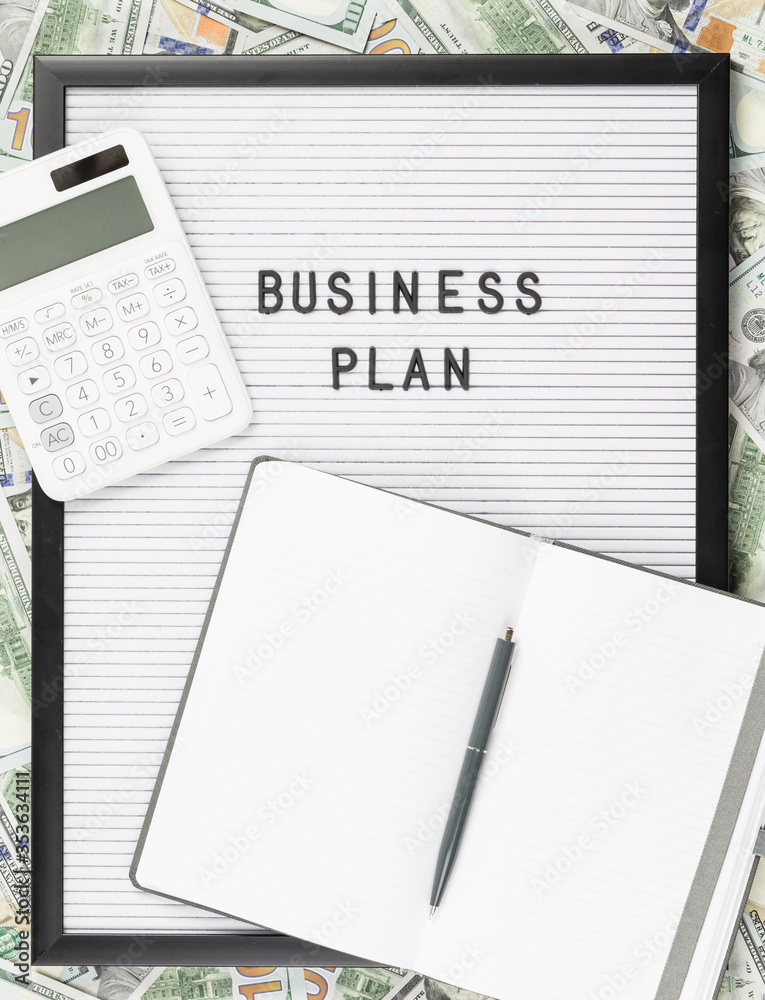 Business Plan text on letter board and open notebook with pen and ...