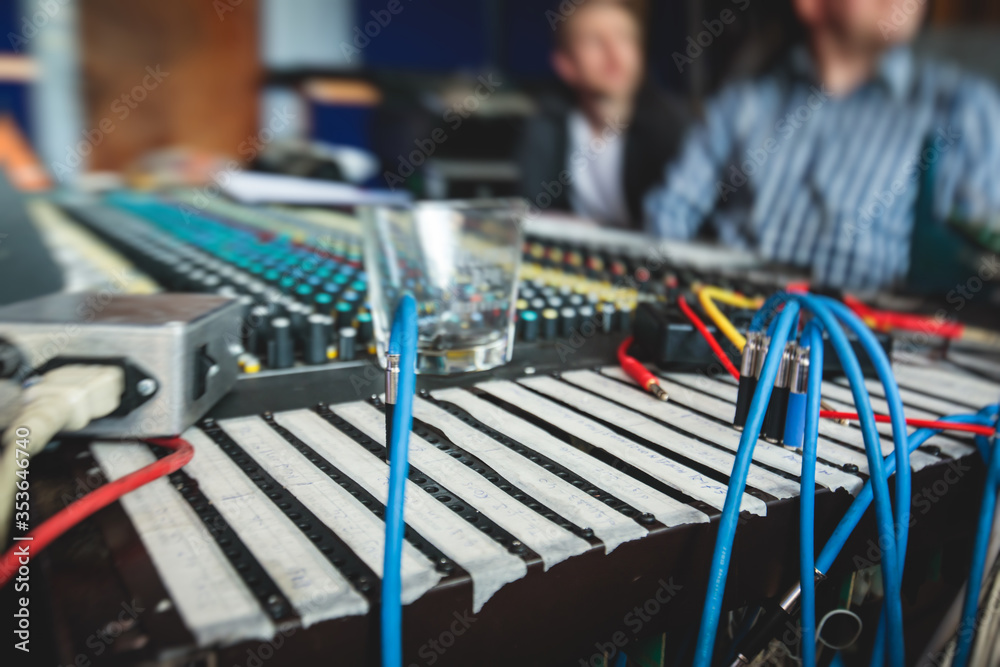 Sound editor engineer working at studio with mixing panel, mixing music ...