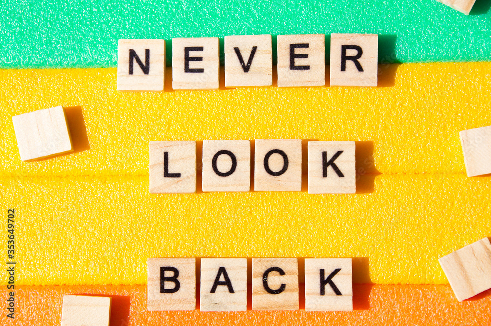 Words written on wooden blocks. Colorful background. Never look back ...
