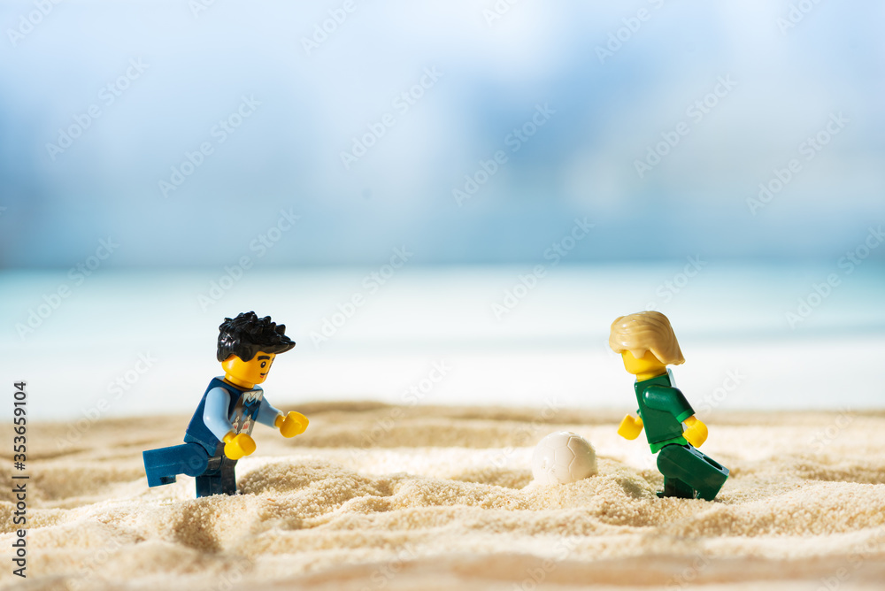Lego minifigures on sandy beach. Two boys plaing foolball. Summer ...