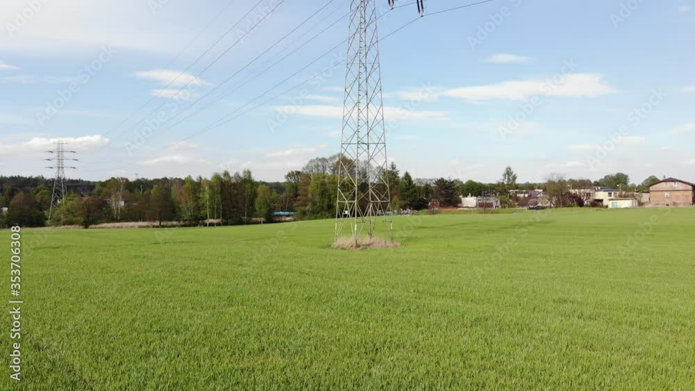Power pylons and high voltage lines in an agricultural landscape. High ...