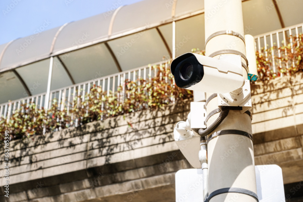 Modern public CCTV camera on a electric pole with blurred crossway ...
