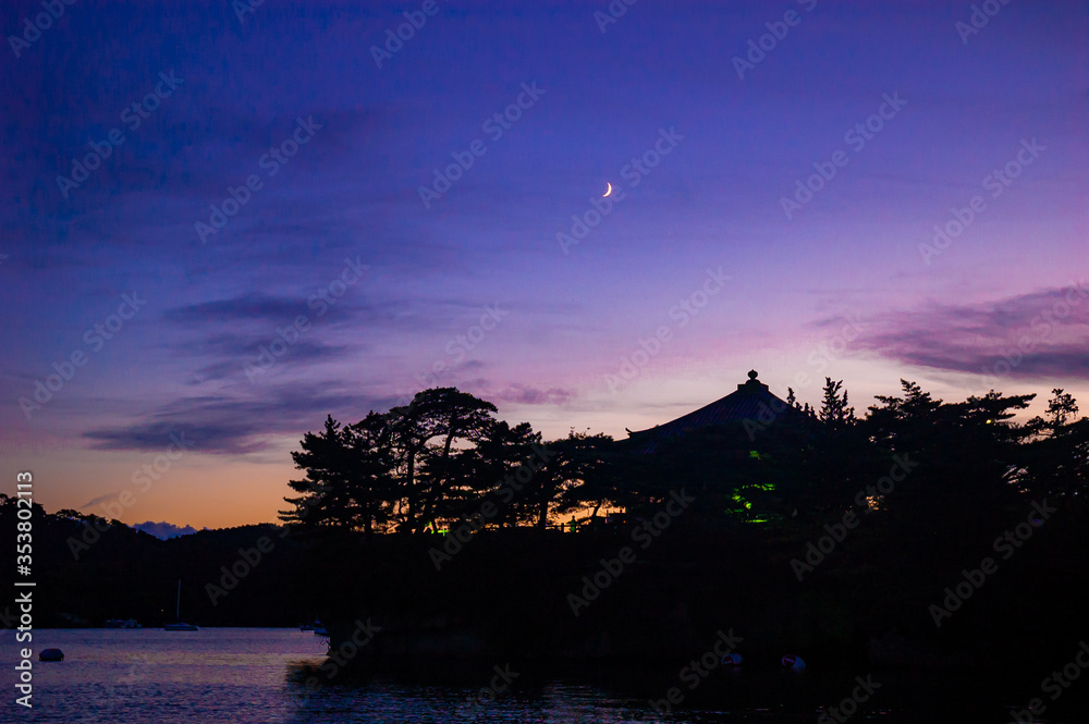 Crescent moon over the silhouette of traditional Japanese temple in ...