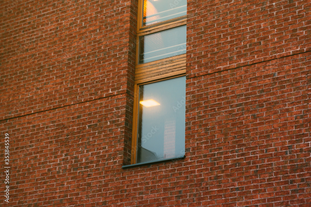 Part of old brick building with one window where light is on Stock ...