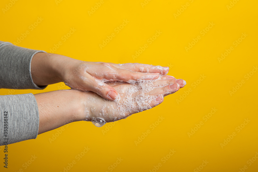 washable hands close-up on a yellow studio background. Proper hand ...