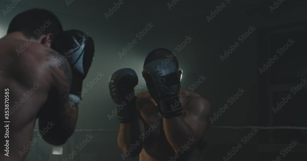 Close up of brutal fight of two male shirtless and strong men boxers ...
