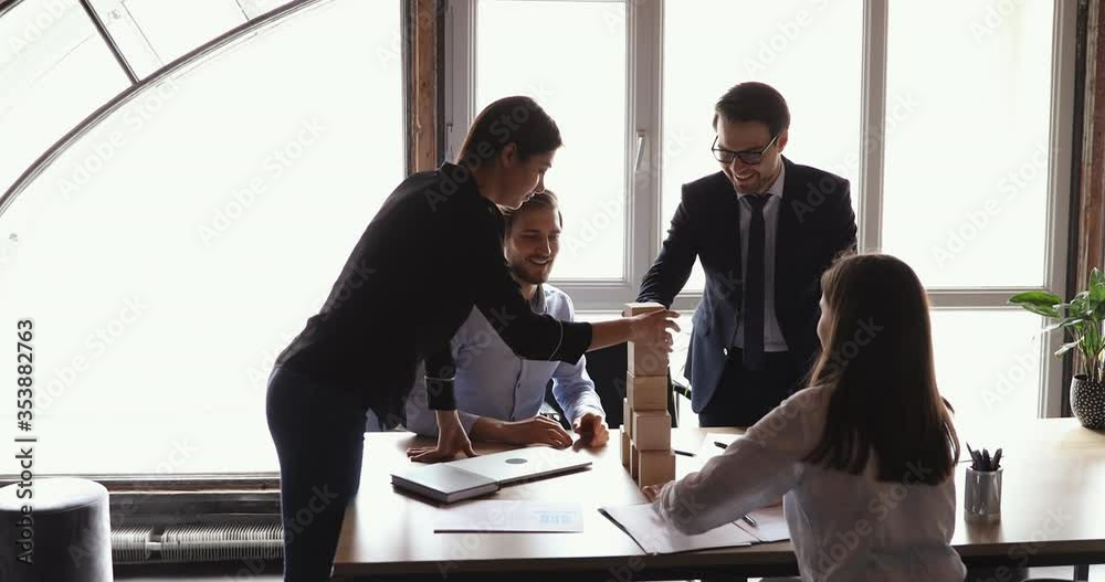 Multiethnic business team people building tower of wooden blocks on ...