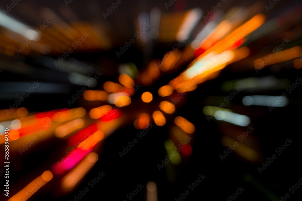 The abstract bokeh of the animated night in the street depicts the ...
