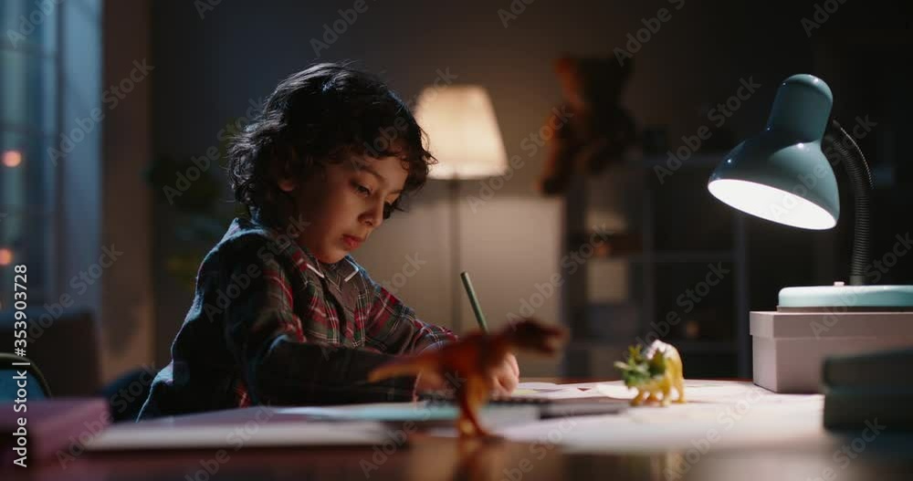 Funny little asian kid drawing at home. Boy with curly hair using his ...