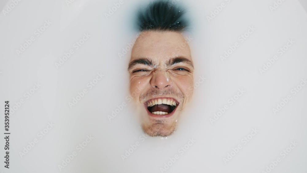 Portrait of funny man do crazy laughing in milk bath, evil laughter ...