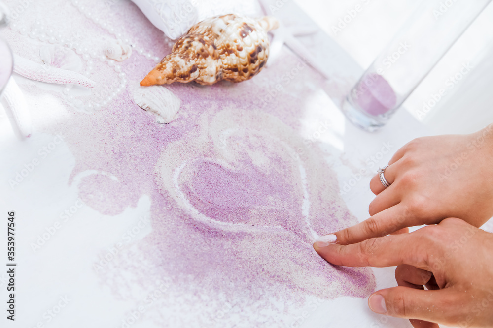 Bride and groom pouring colorful different colored sands into the ...