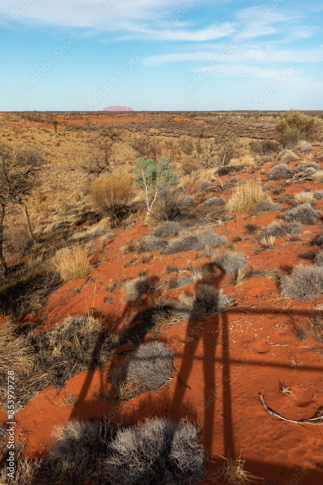 Shade of two tourists taking pictures of mount Uluru at sunset time ...
