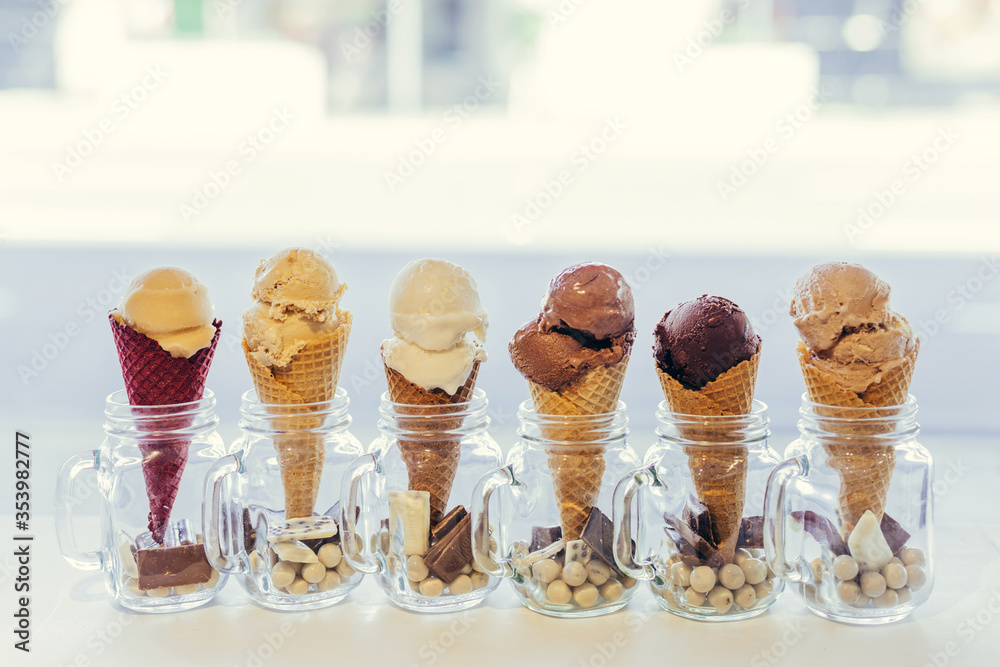 Six ice creams with different tastes in a line standing in the jars ...