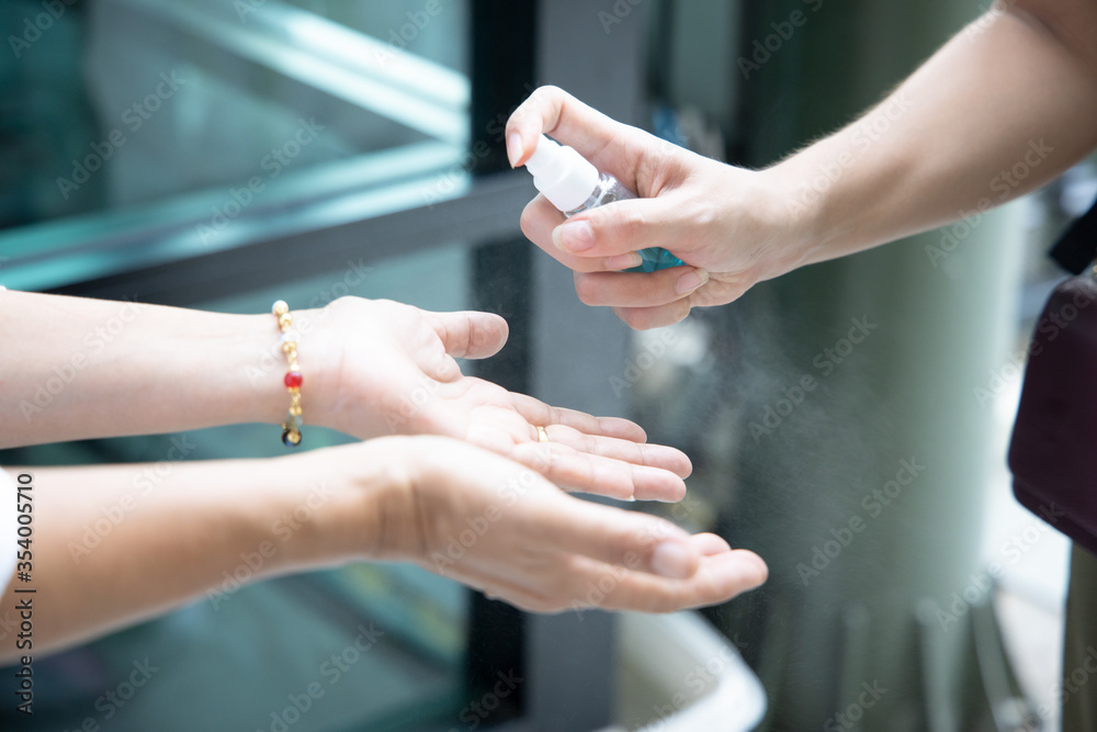 people using alcohol hand spray to kill germs on palm skin; concept of ...