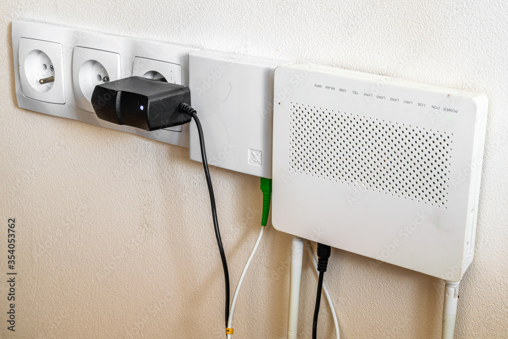 electrical outlets and internet modem on a cream wall background Stock ...