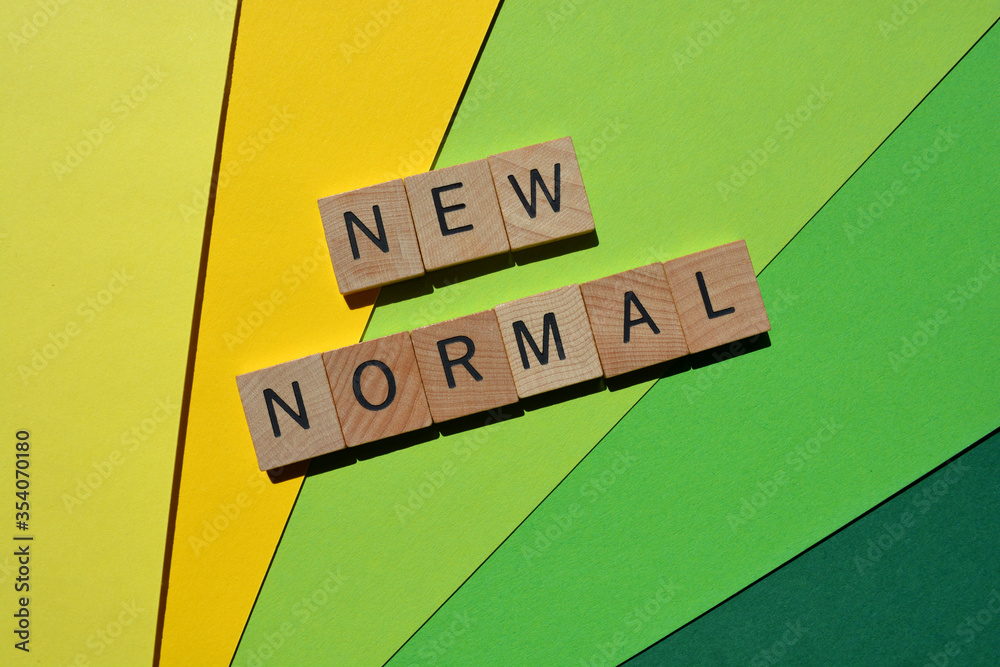New Normal, words in 3d wooden alphabet letters isolated on yellow and ...