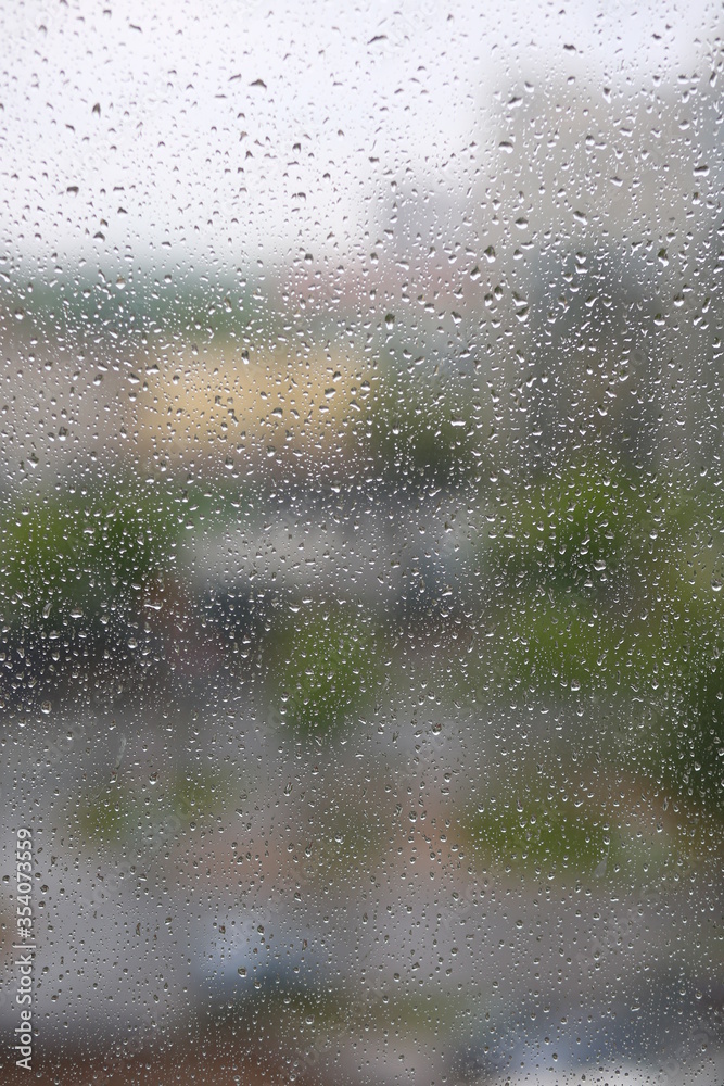 window glass in drops from spring rain on a blurred background of ...