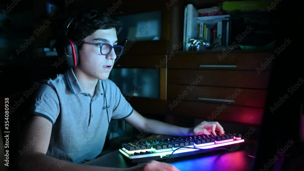 Game action during a video gaming session. The Caucasian boy with wavy ...