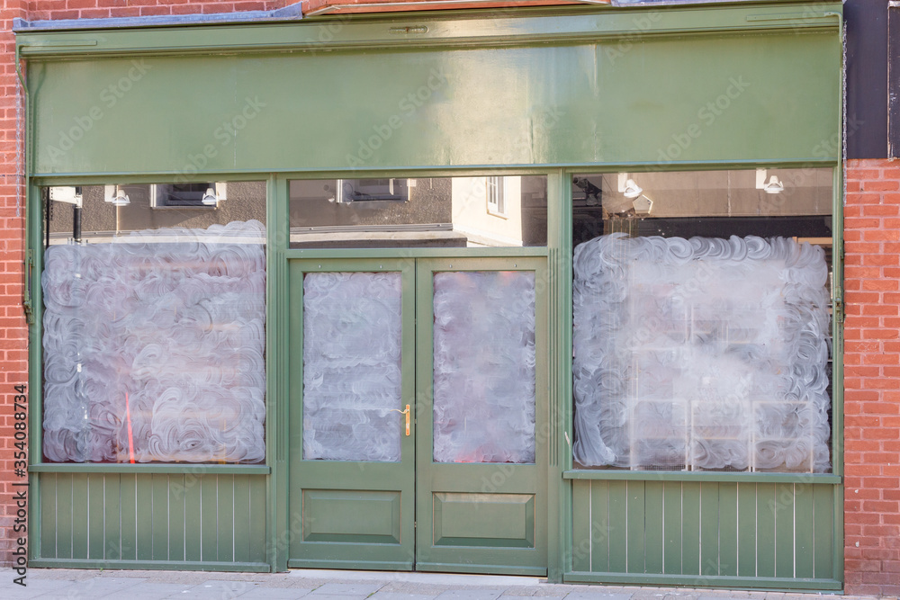 Small Shop With Green Facade and White Paint Covering the Doors and ...