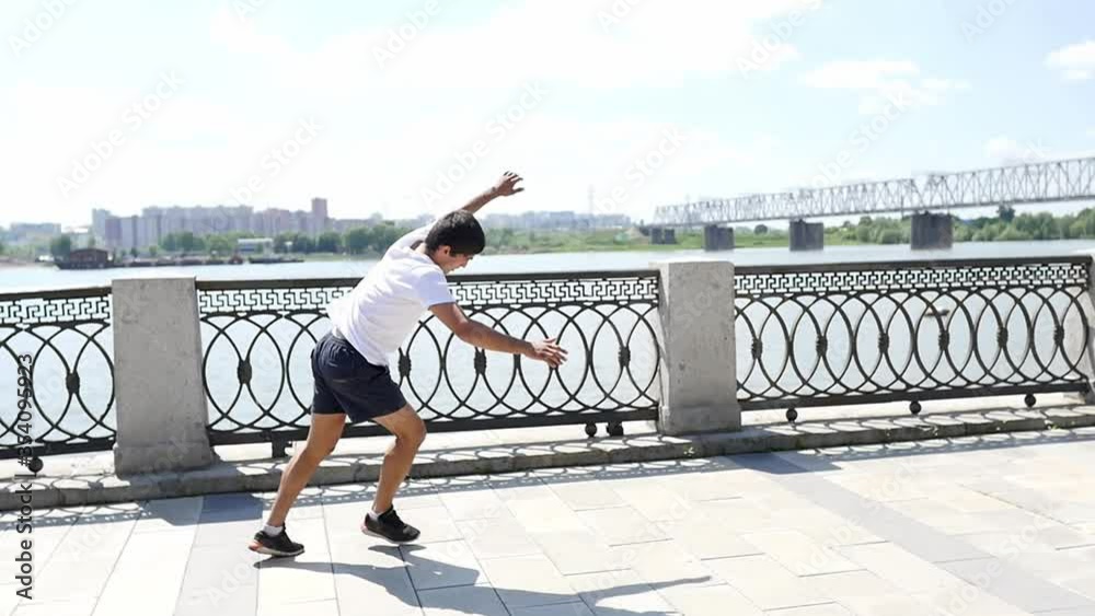 A young gymnast runs around the city and does a series of somersaults ...
