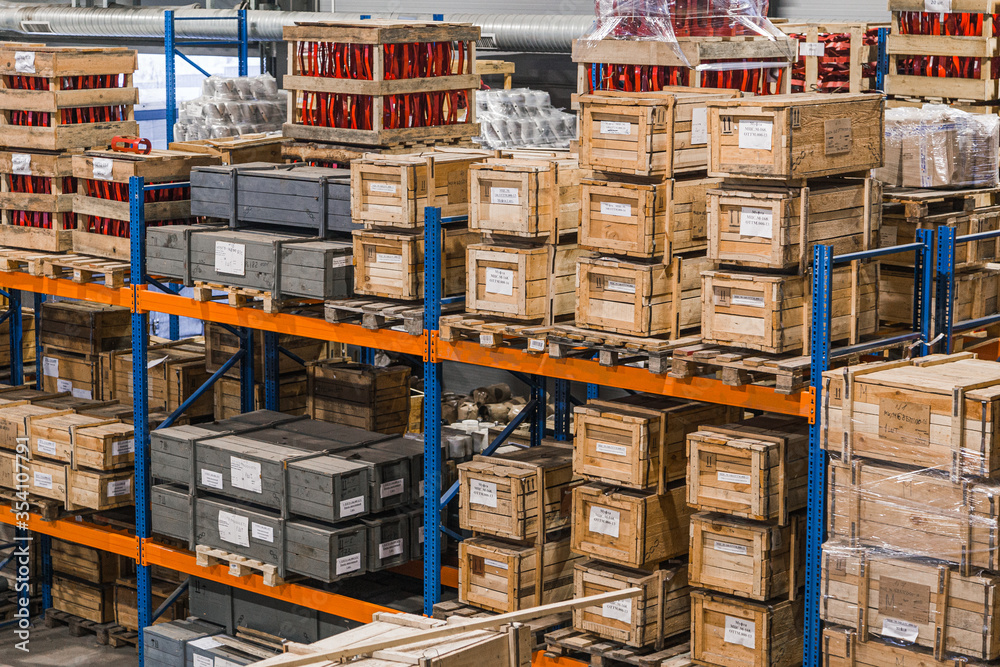 Warehouse with racks and shelves, filled with wooden boxes on pallets ...