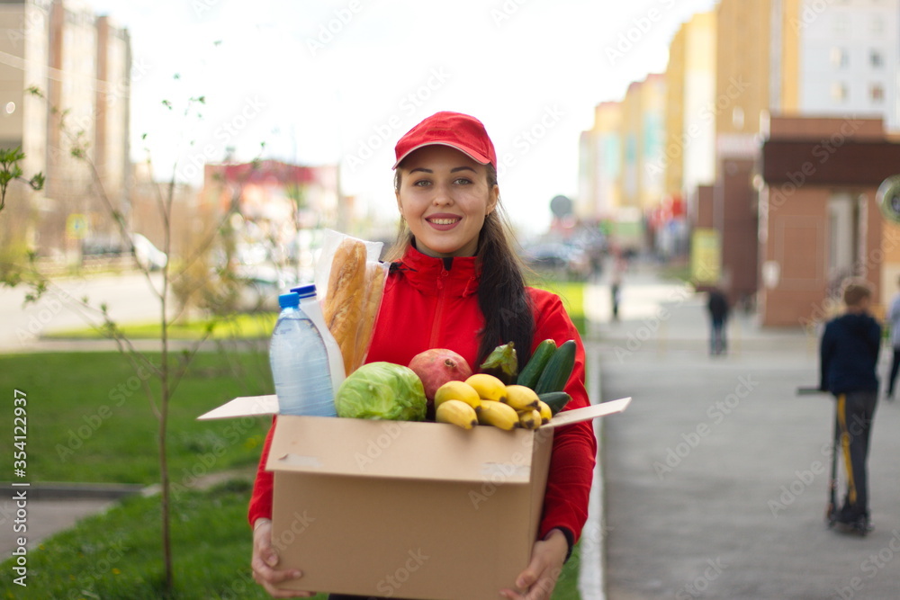 Courier girl with a box of food on the street. The girl from the ...