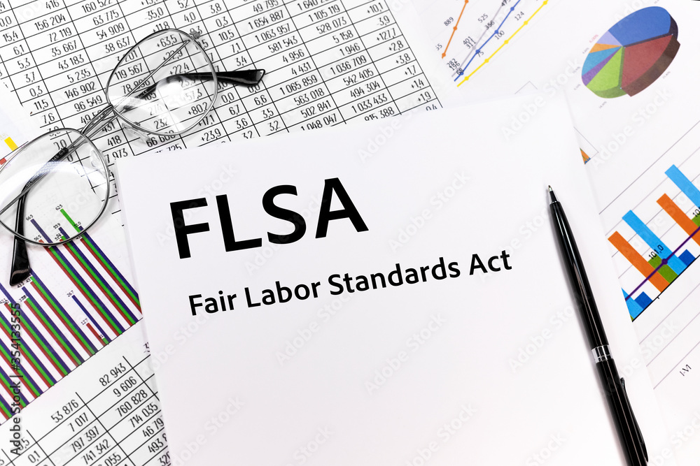 text FLSA fair labor standards act written on the sheet. pen, glasses ...