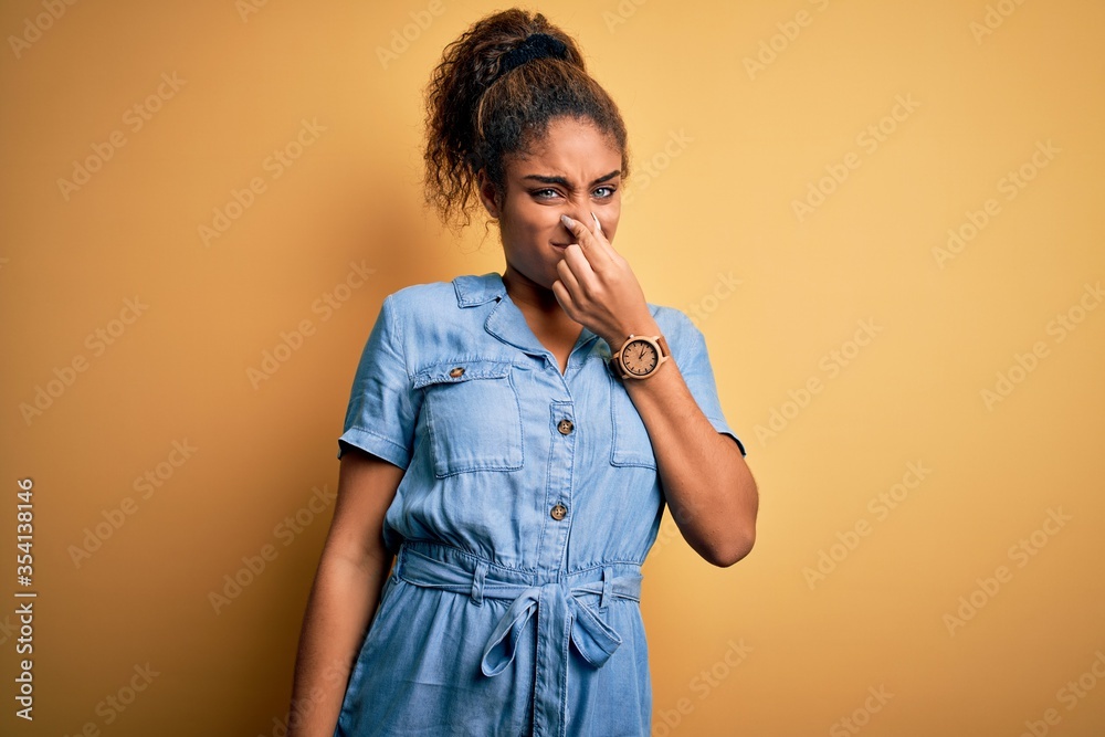 Young beautiful african american girl wearing denim dress standing over ...