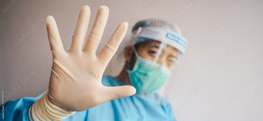 Doctor wearing PPE suit for protect virus and show stop hand gesture ...