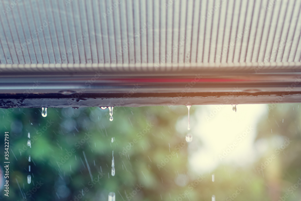 Water flowing from the roof due to heavy rain, drops of heavy rain when ...