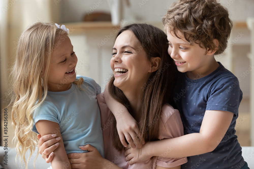 Overjoyed young mother play with excited little preschooler children ...