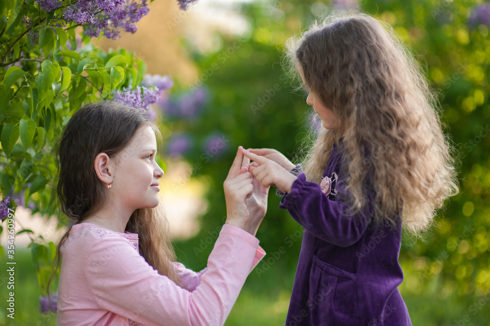 Two sisters play together outside the house in nature. Stock Photo ...