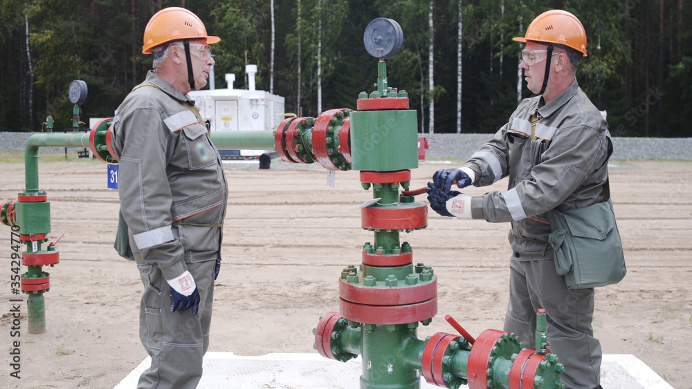 Fotografia do Stock: Man oil engineer overseeing Cross type X-mass tree ...