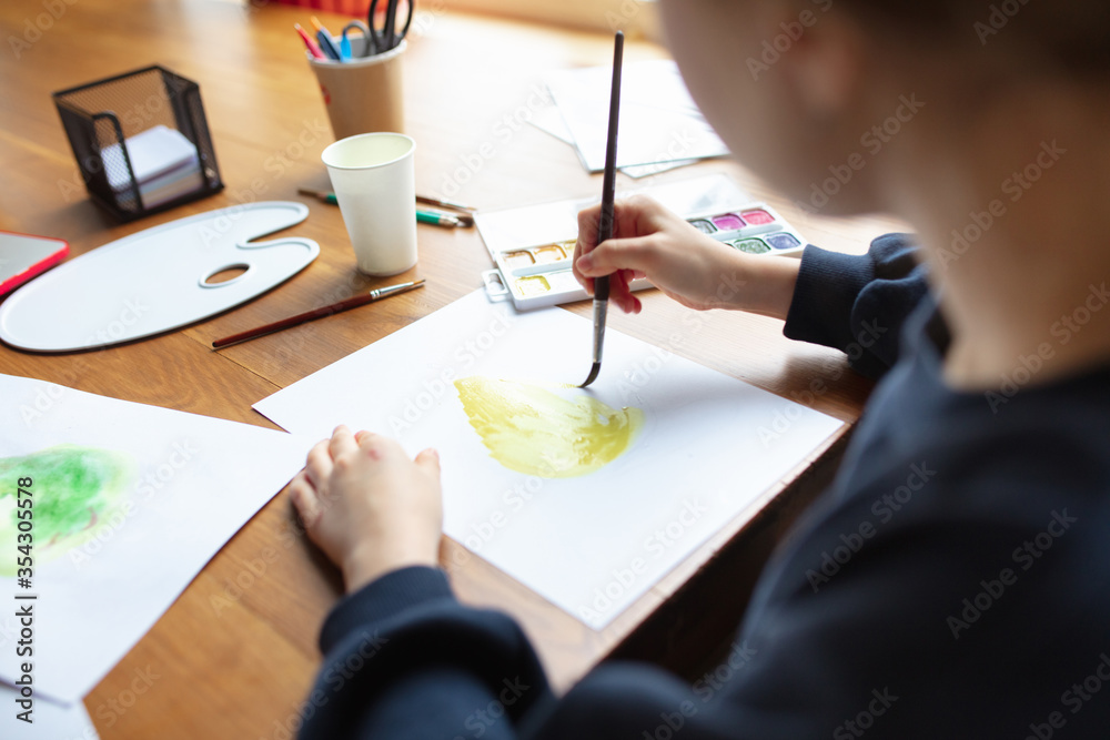 Close up girl drawing with paints and pencils at home, using tutorials ...