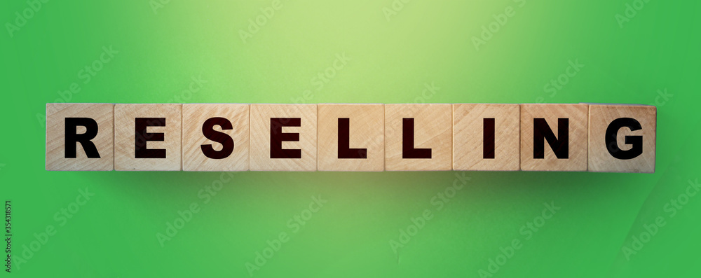 Resselling word wooden cubes on the green background. Business model ...