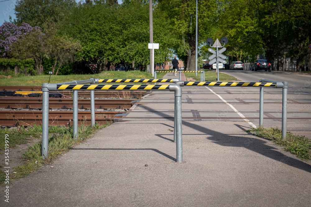 Pedestrian crossing across railway lines. Safety barriers and warning ...
