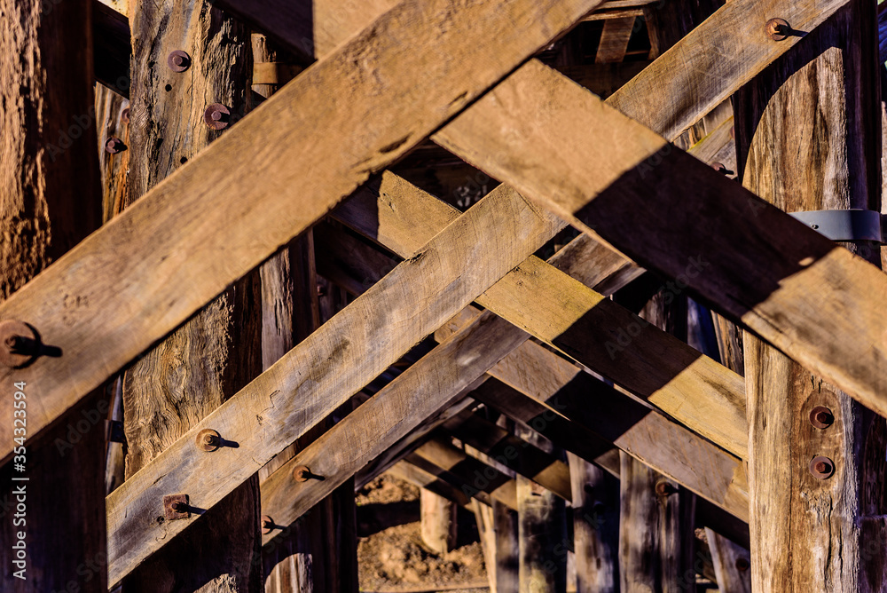 Diagonal wooden beams are used under a suburban rail bridge Stock Photo ...