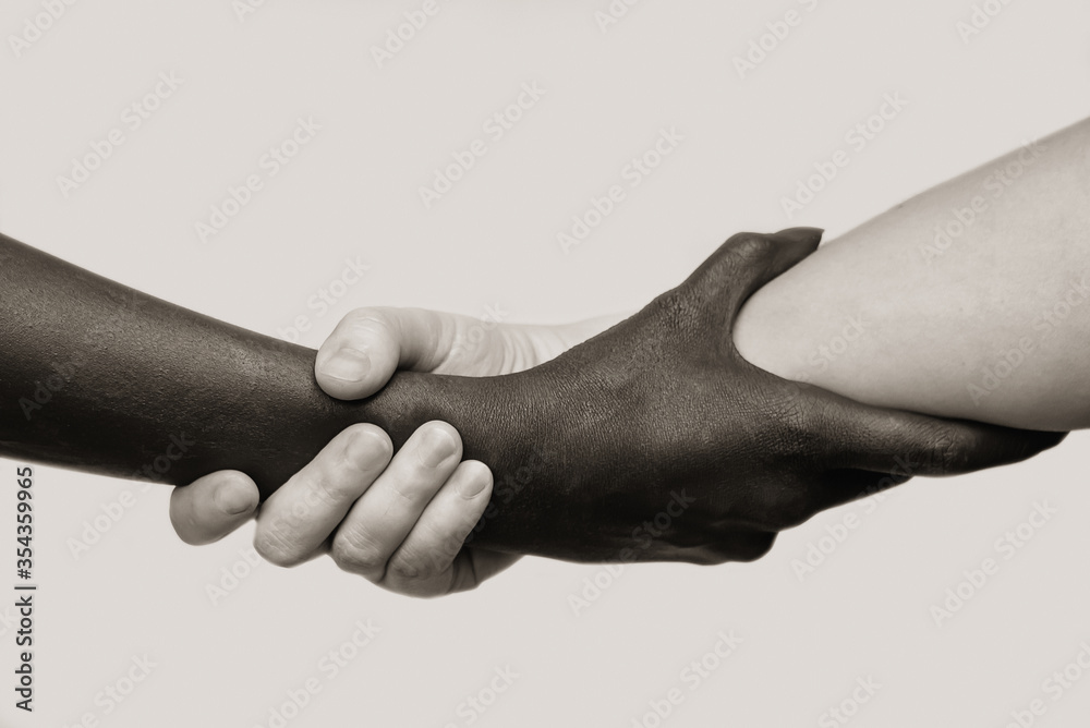 Black-and-white human arms wrapped tightly around each other . The ...
