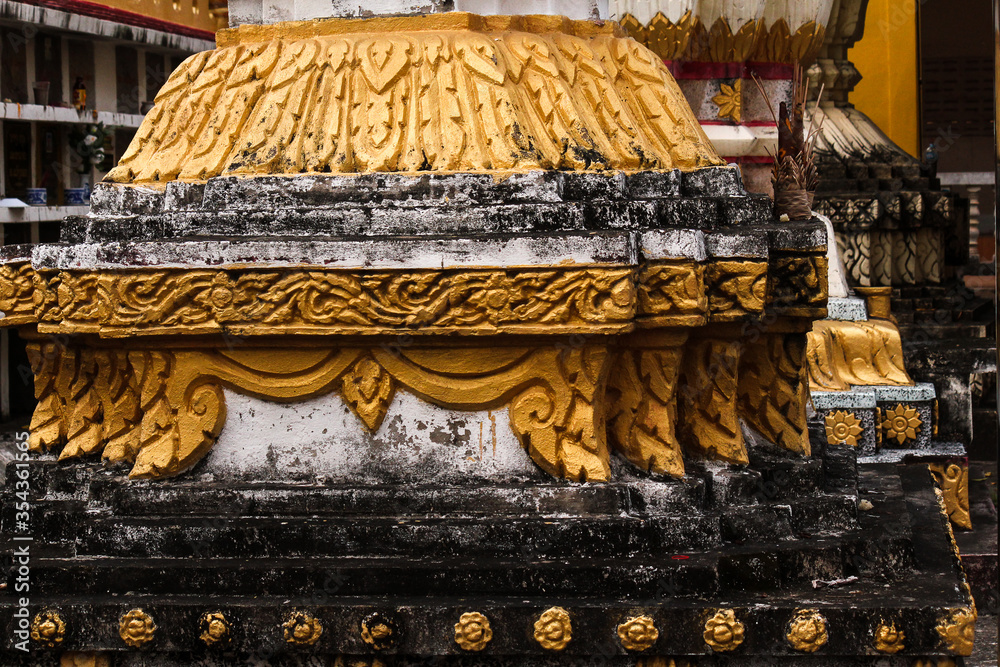 Fundaments of a stony and golden painted stupa in front of a protecting ...
