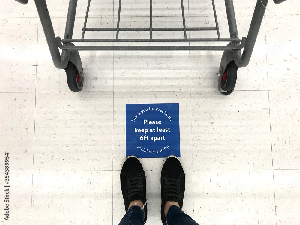 Social distancing sign for people line up in front of grocery store or ...