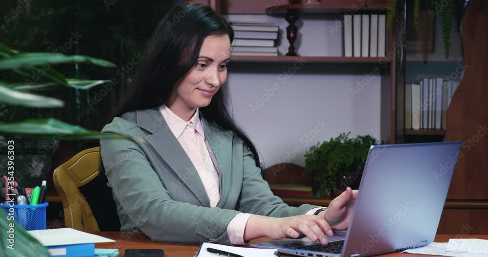 Smiling young woman type on laptop notebook looking at screen typing ...