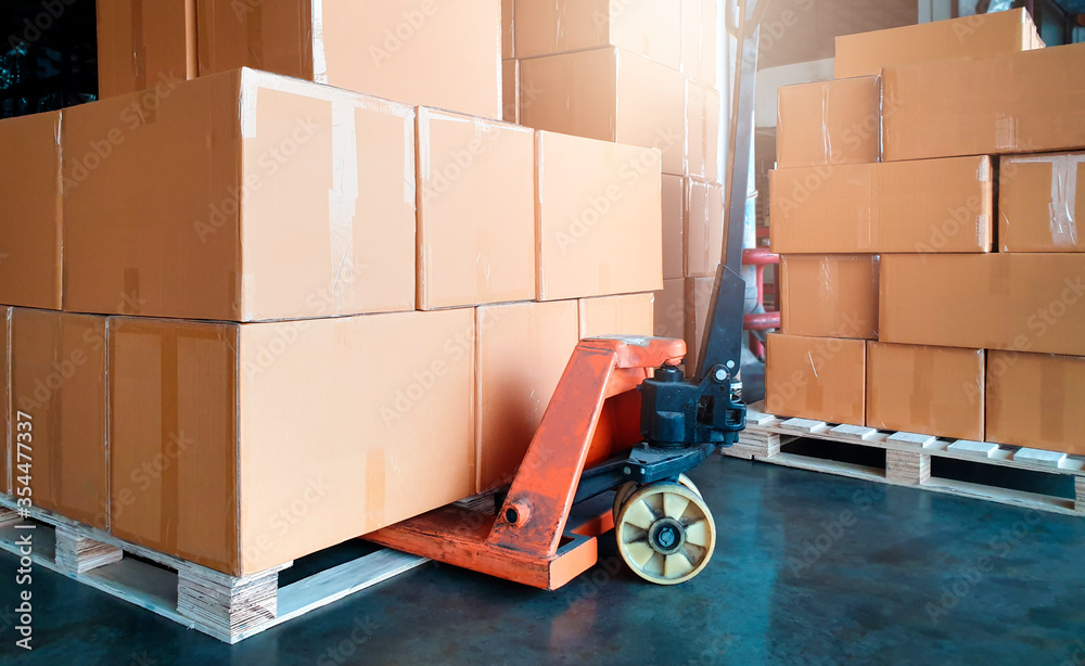 Stack of shipment boxes on pallet and hand pallet truck. Interior of ...