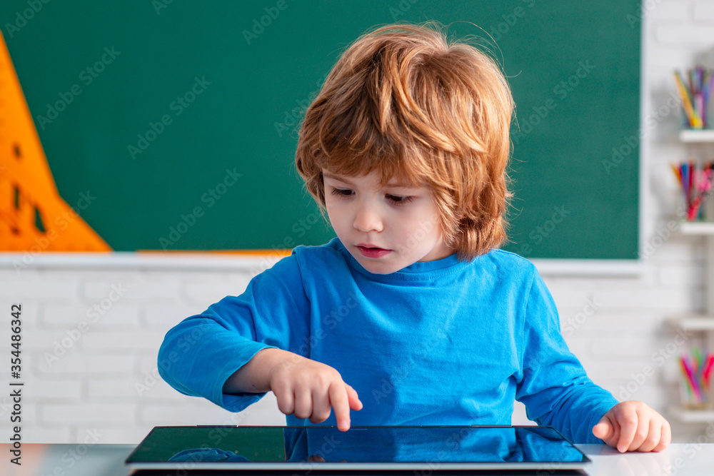 School child with tablet in school classroom. Children learning. Kids ...