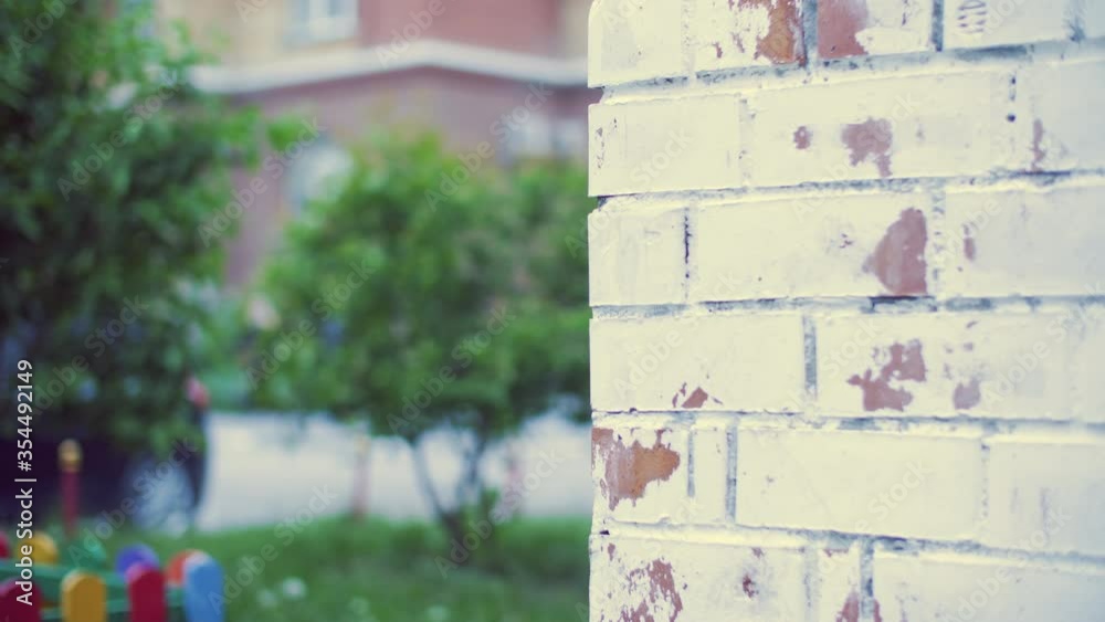 Scared little girl hiding behind corner of brick wall. Frightened ...