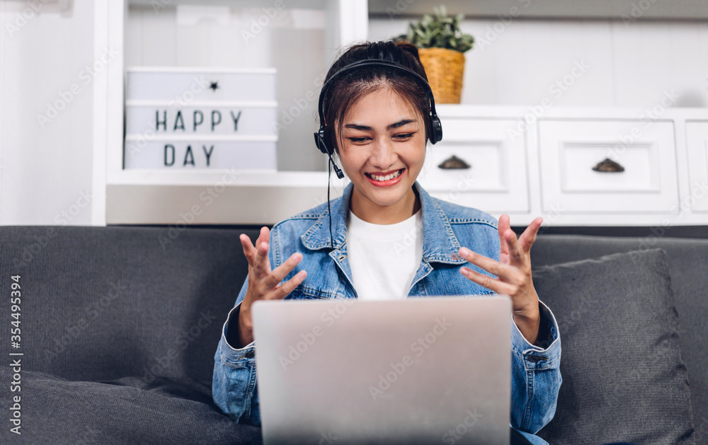 Young smiling happy beautiful asian woman relaxing using laptop ...