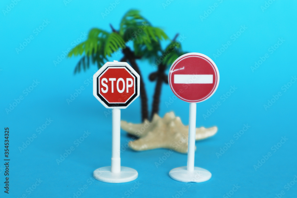 Stop signs on the background of a miniature island with a palm tree ...