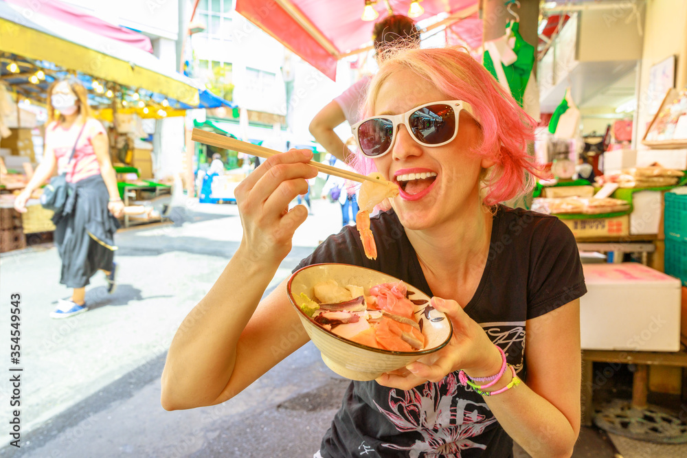 Caucasian lifestyle happy tourist woman eats with chopsticks, sashimi ...